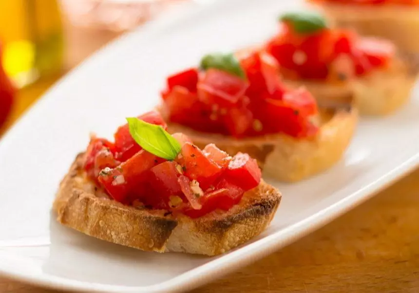 Bruschetta con tomates y albahaca.