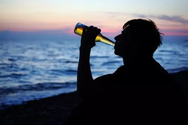 človek pije na obali