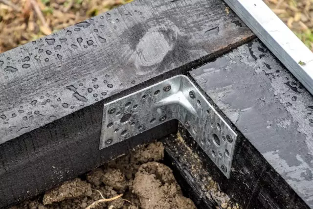 Installation of polycarbonate greenhouses. Greenhouse for the home garden. Fastening the corners of the joints of a wooden bar in the greenhouse.