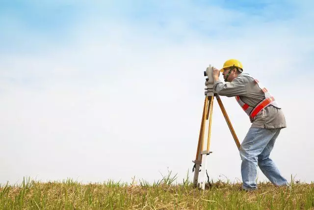 Surveyor engineer na gumagawa ng sukatan sa field