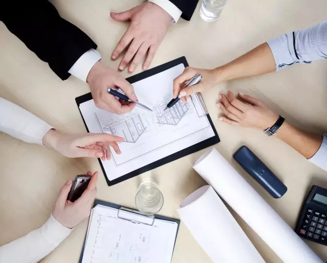 Mãos de pessoas de negócios na mesa na reunião no escritório. VISTA DO TOPO.