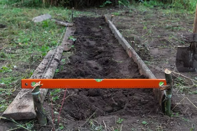 Utgravningsarbeid på gården, forbereder senger for planting av frøplanter