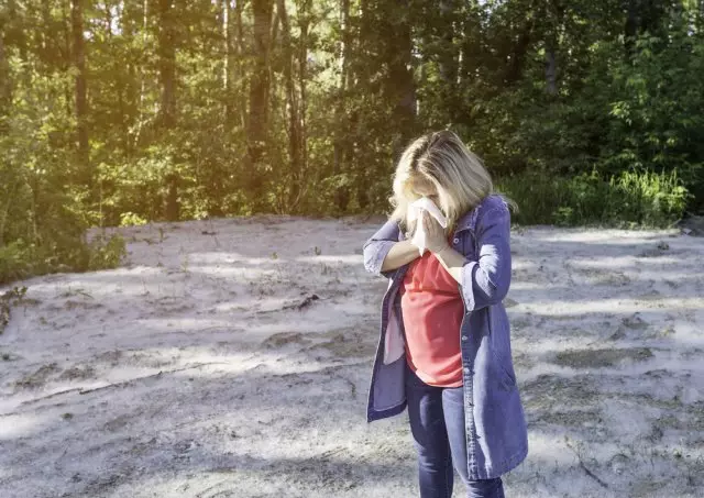 Jonge vrouw lijdt de allergie van de lente stuifmeel. Populier bloei seizoen.