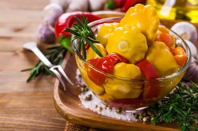 Marinated yellow pattypan and paprika on a wooden background. Selective focus.